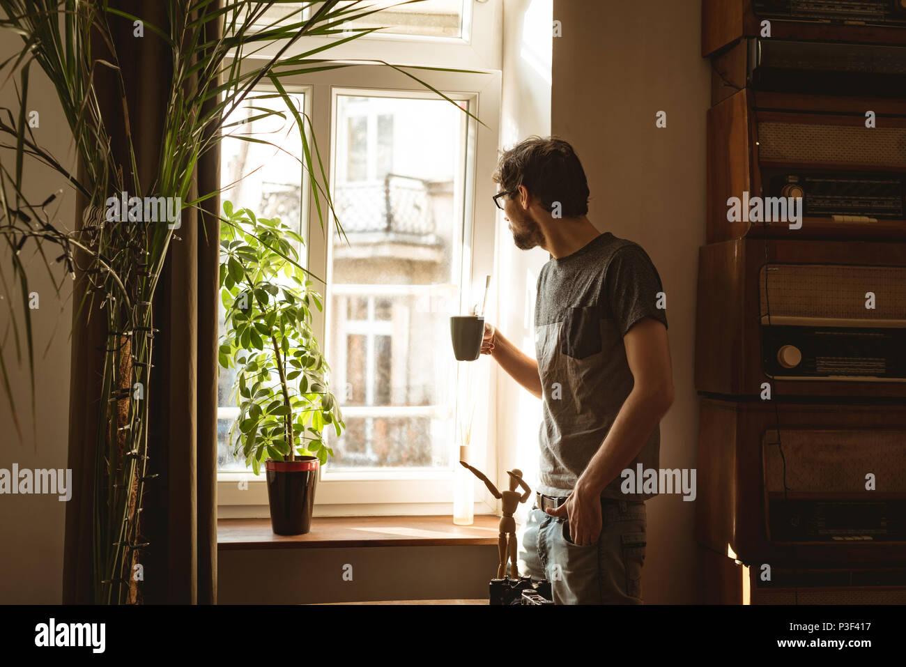 Man having coffee while through window Stock Photo - Alamy