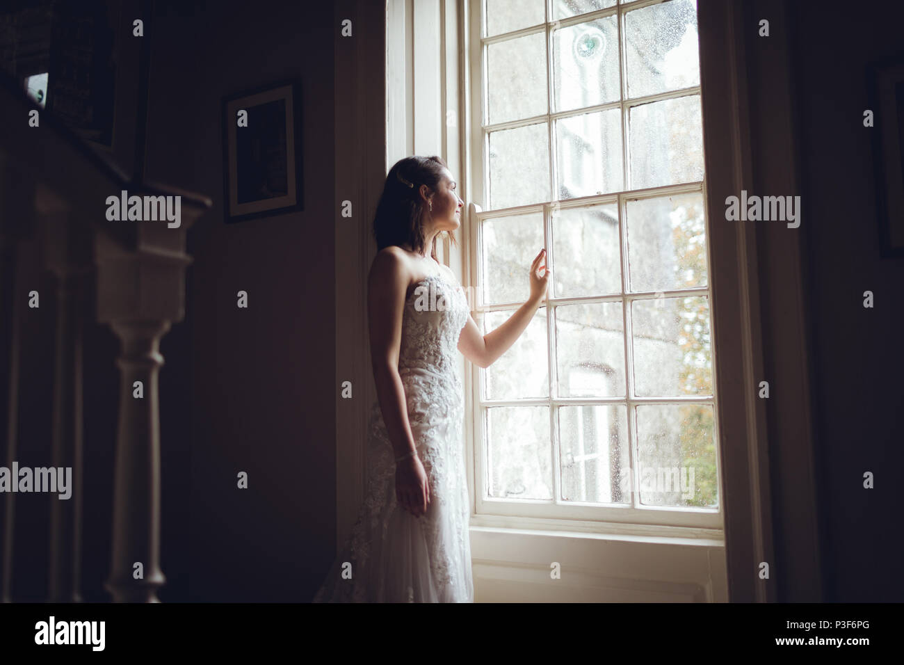 Bride looking out of the window at home Stock Photo - Alamy