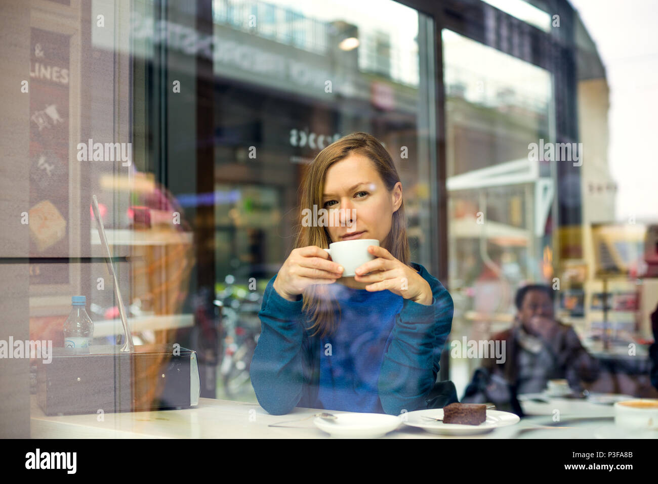 beautiful woman drinking coffee sitting by the window Stock Photo - Alamy