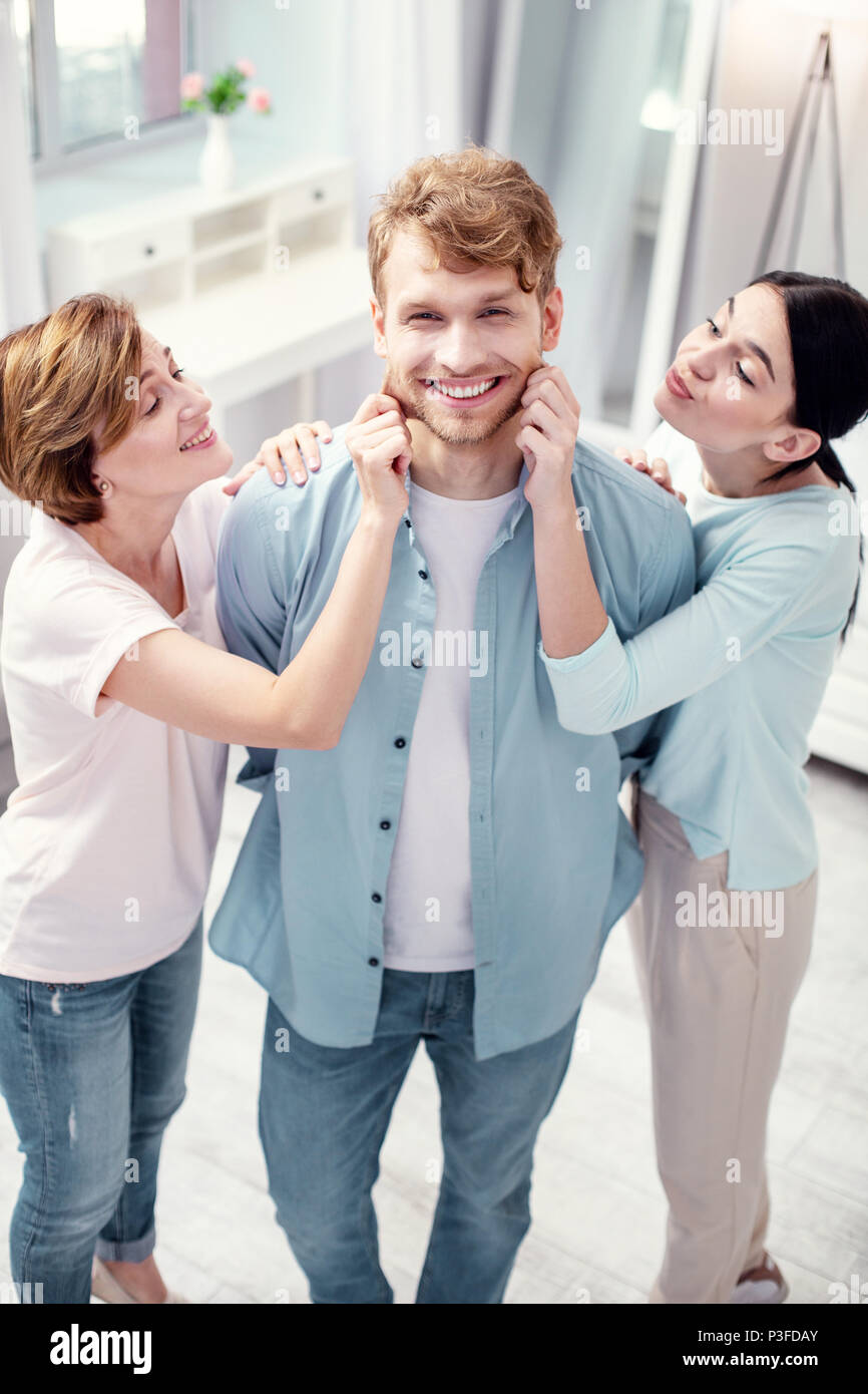 Joyful young man being in the center of attention Stock Photo - Alamy