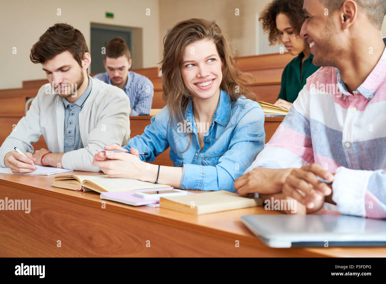 Pretty student girl talking to groupmate at class Stock Photo - Alamy