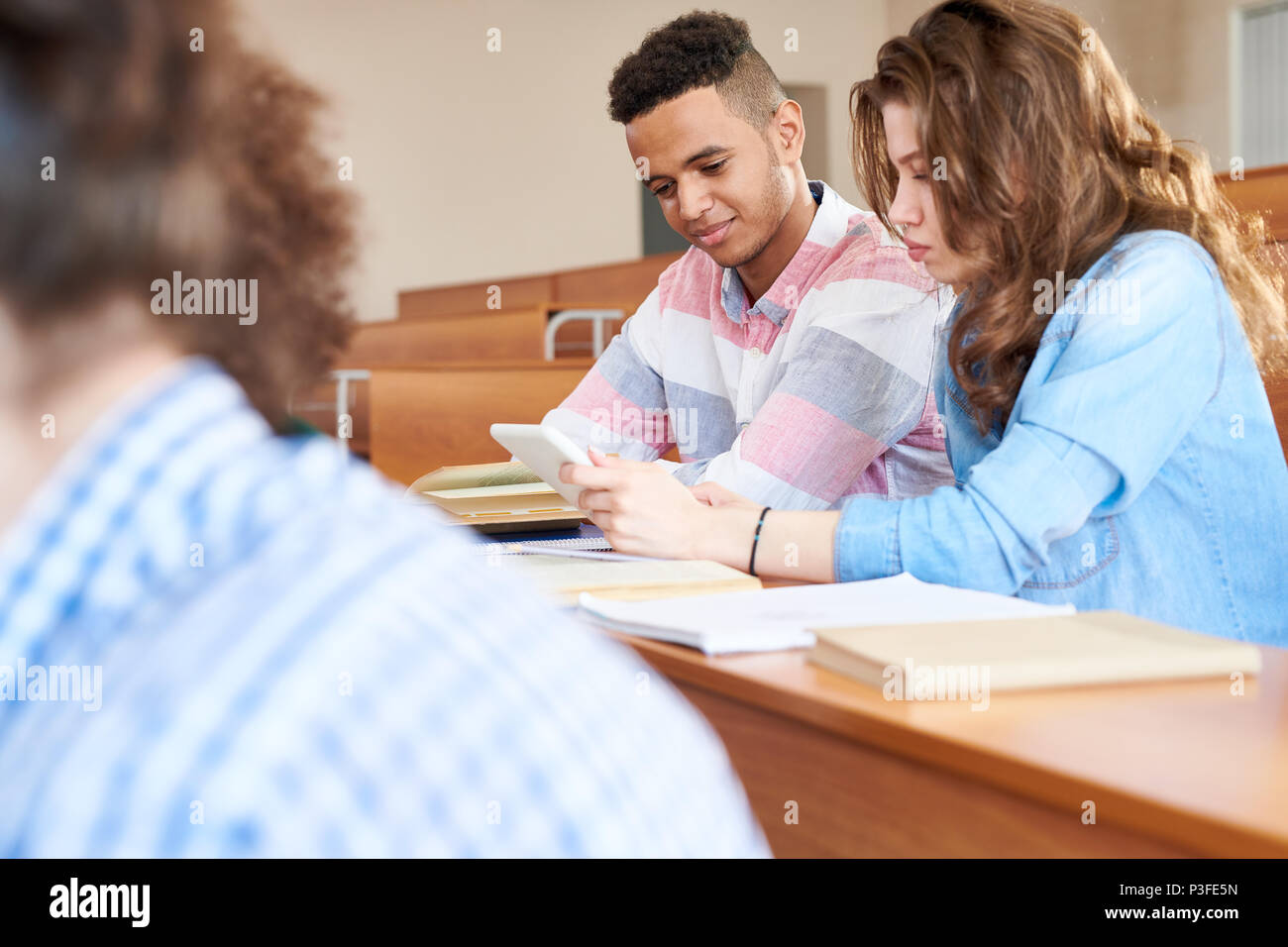 Multiethnic students watching video on gadget Stock Photo - Alamy