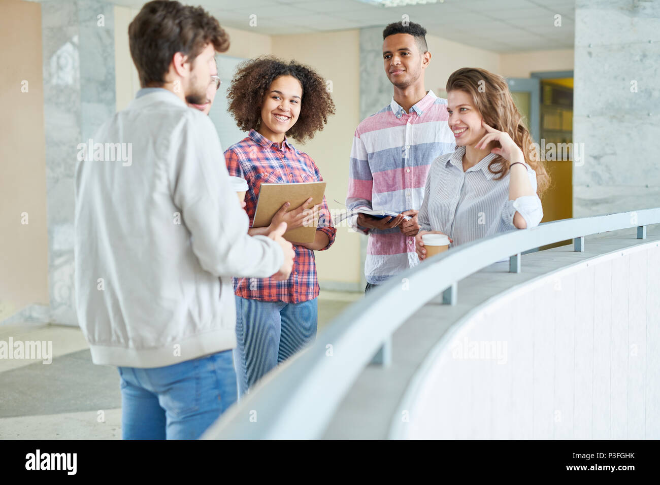 Happy multiethnic friends chatting together Stock Photo - Alamy