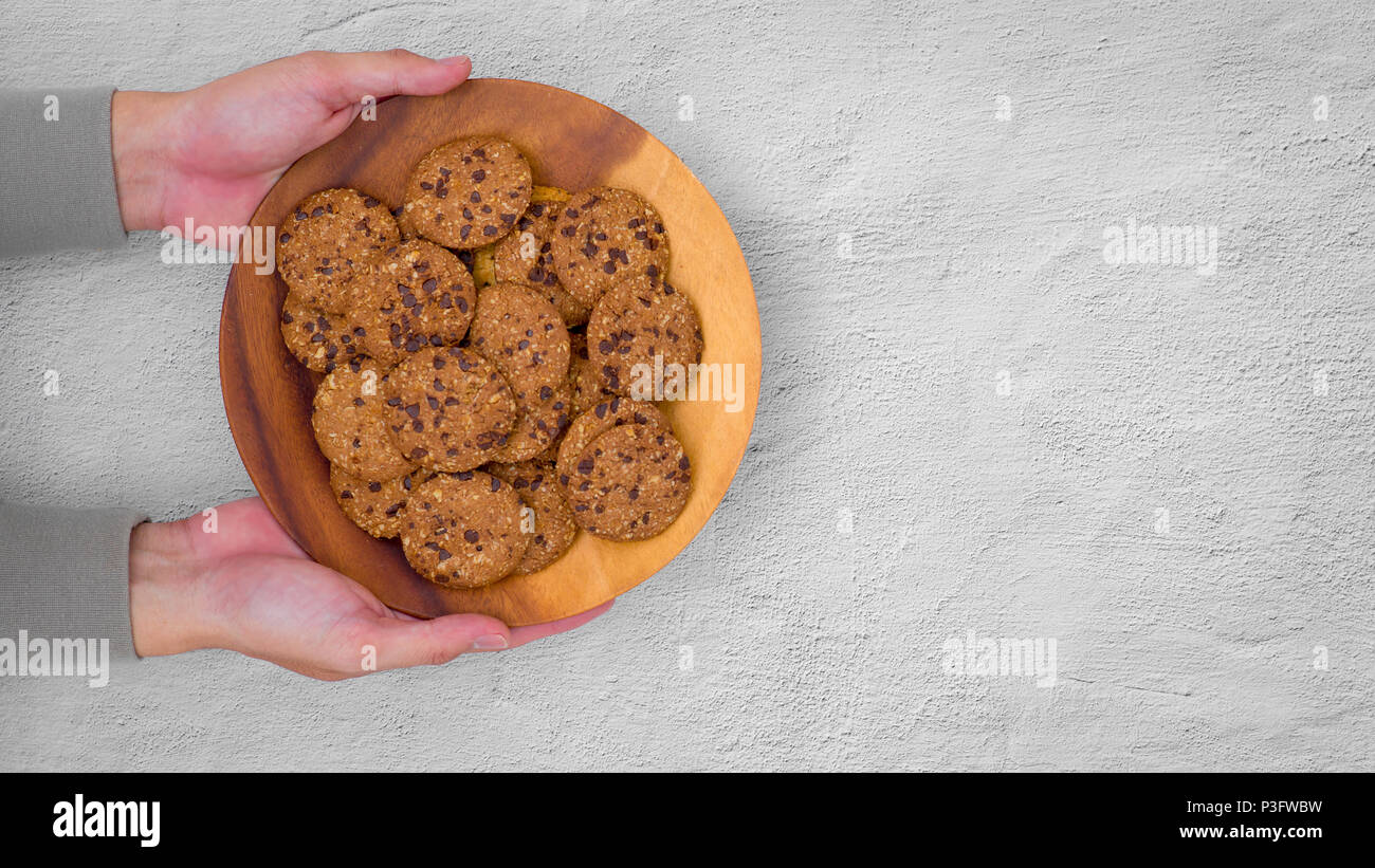 Hands holding plate with traditional chocolate chip cookies Stock Photo ...