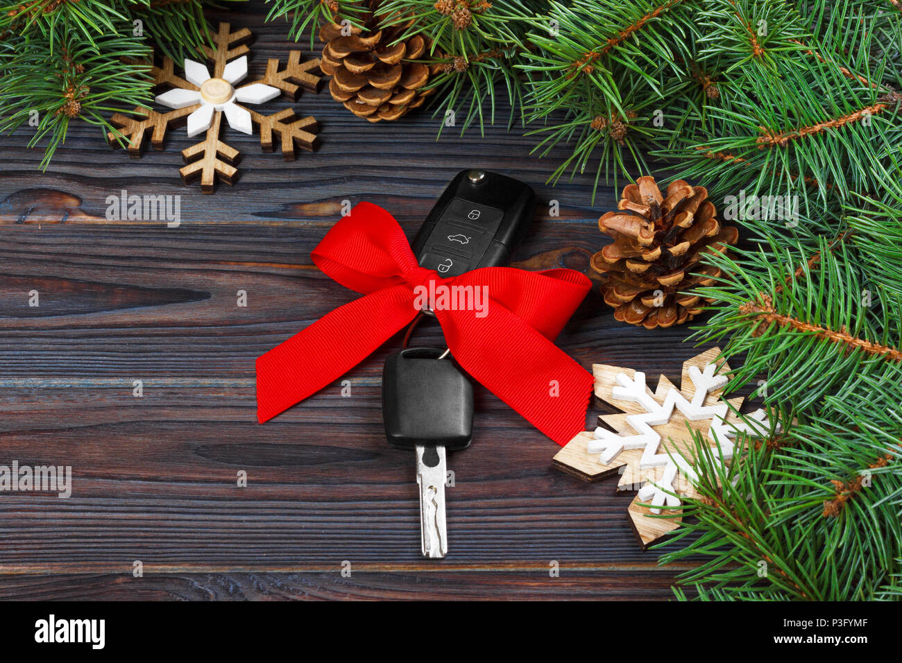 Close-up view of car keys with red bow as present on wooden background ...