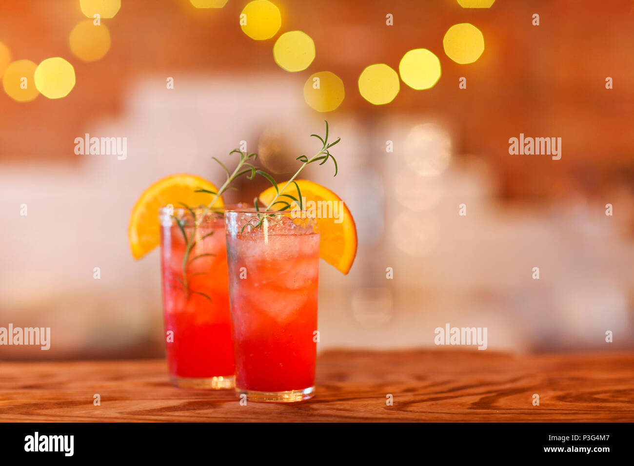 Two red cocktail glasses on wooden bar counter Stock Photo - Alamy