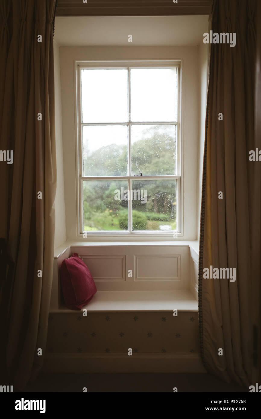 Seating area and a cushion near the window Stock Photo - Alamy