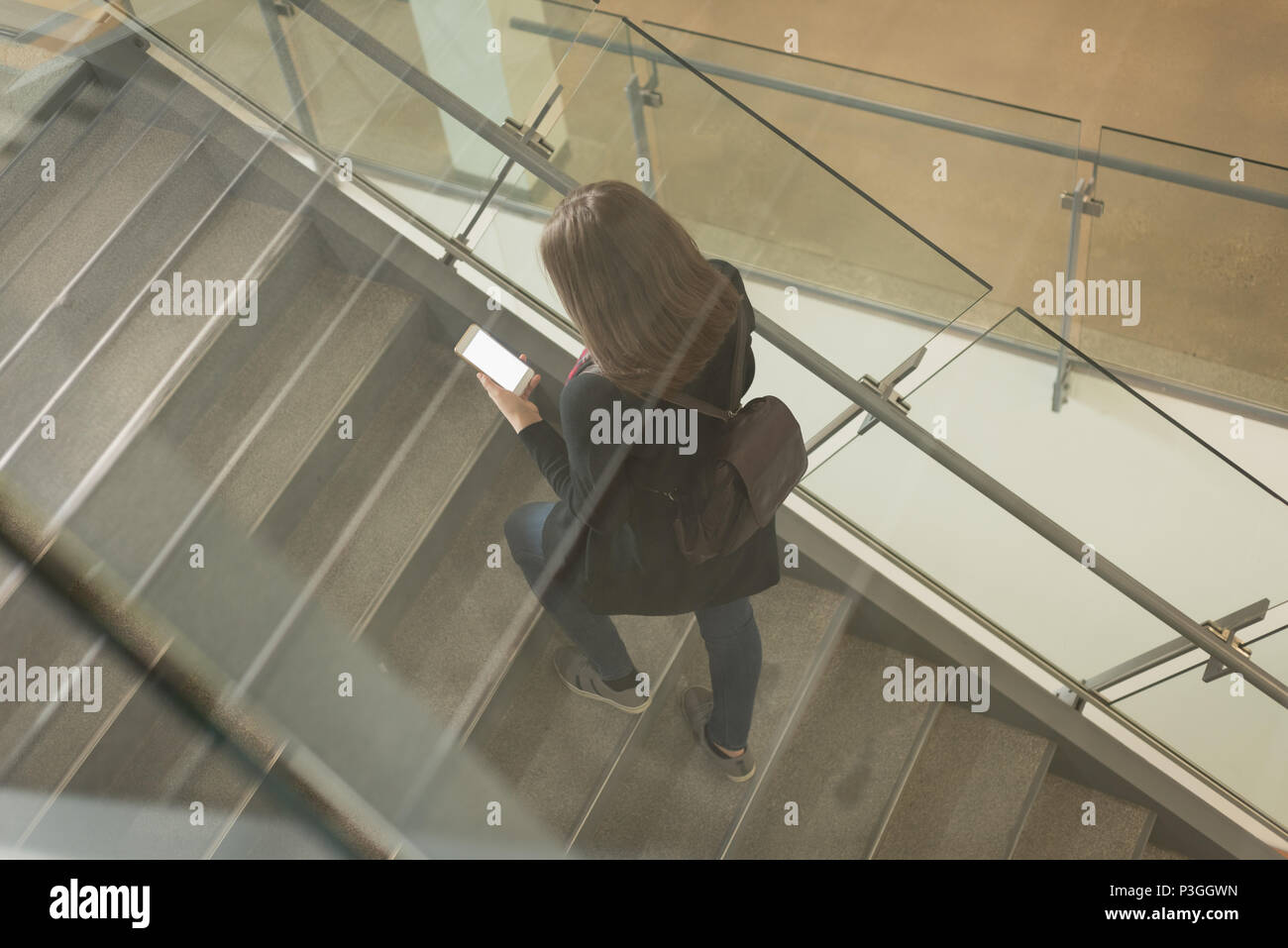 College student using mobile phone on staircase Stock Photo - Alamy