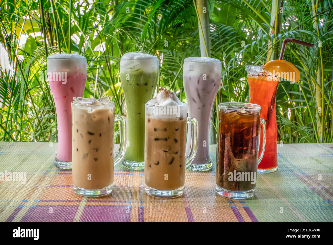 group of iced milk , tea and coffee on table with nature background ...
