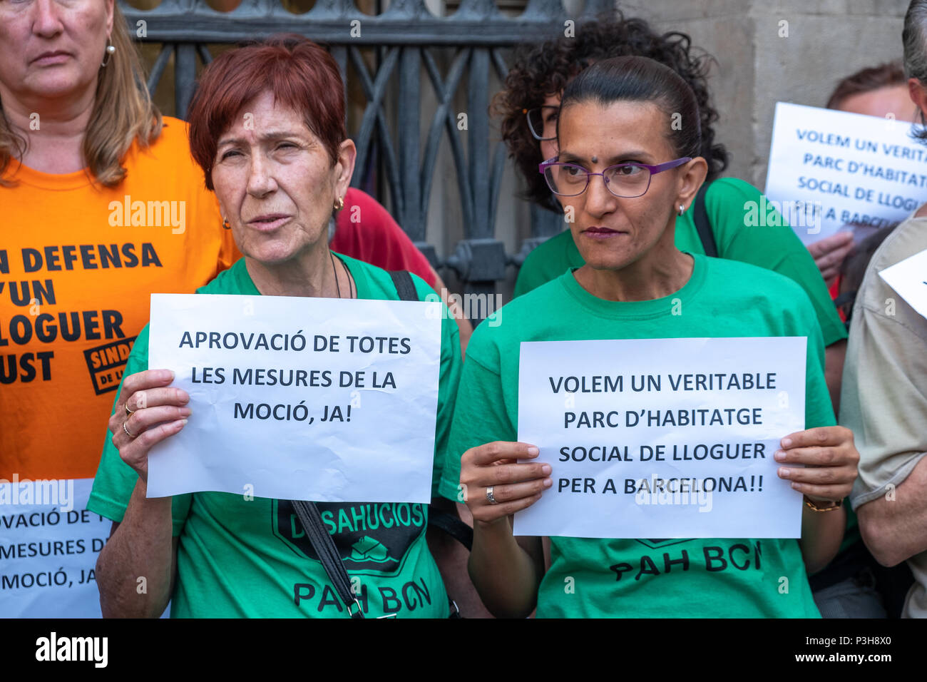 Two social housing activists are seen showing posters with the text ...