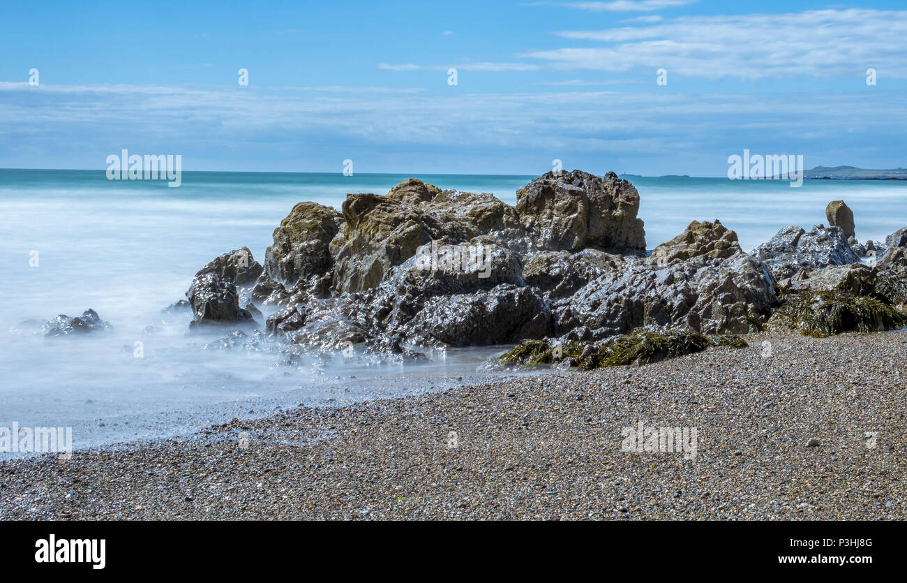 A long exposure image of the sea washing in around rocks at Porth Nobla ...