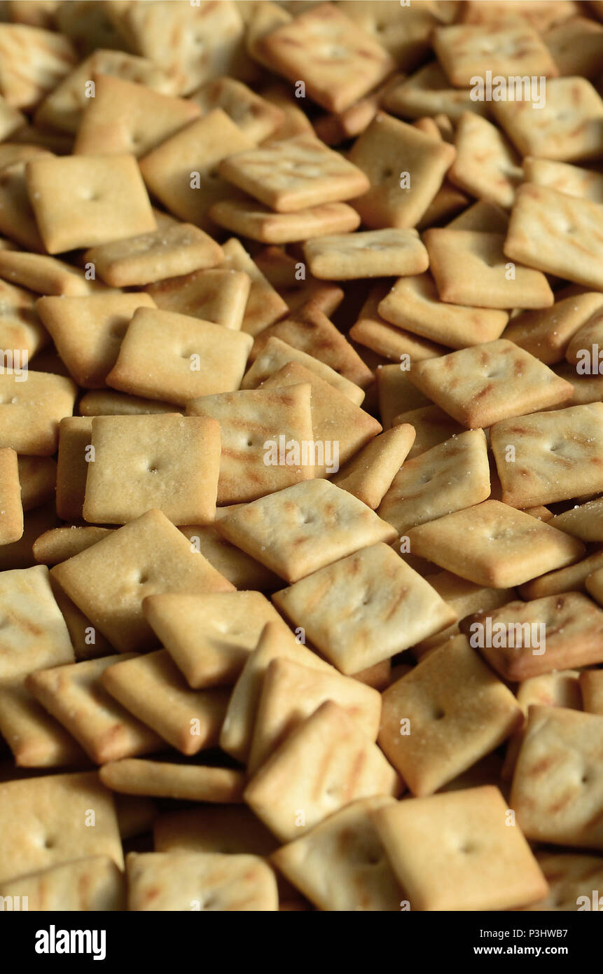 A lot of small cookies are square shaped. A pattern of a yellow salt ...