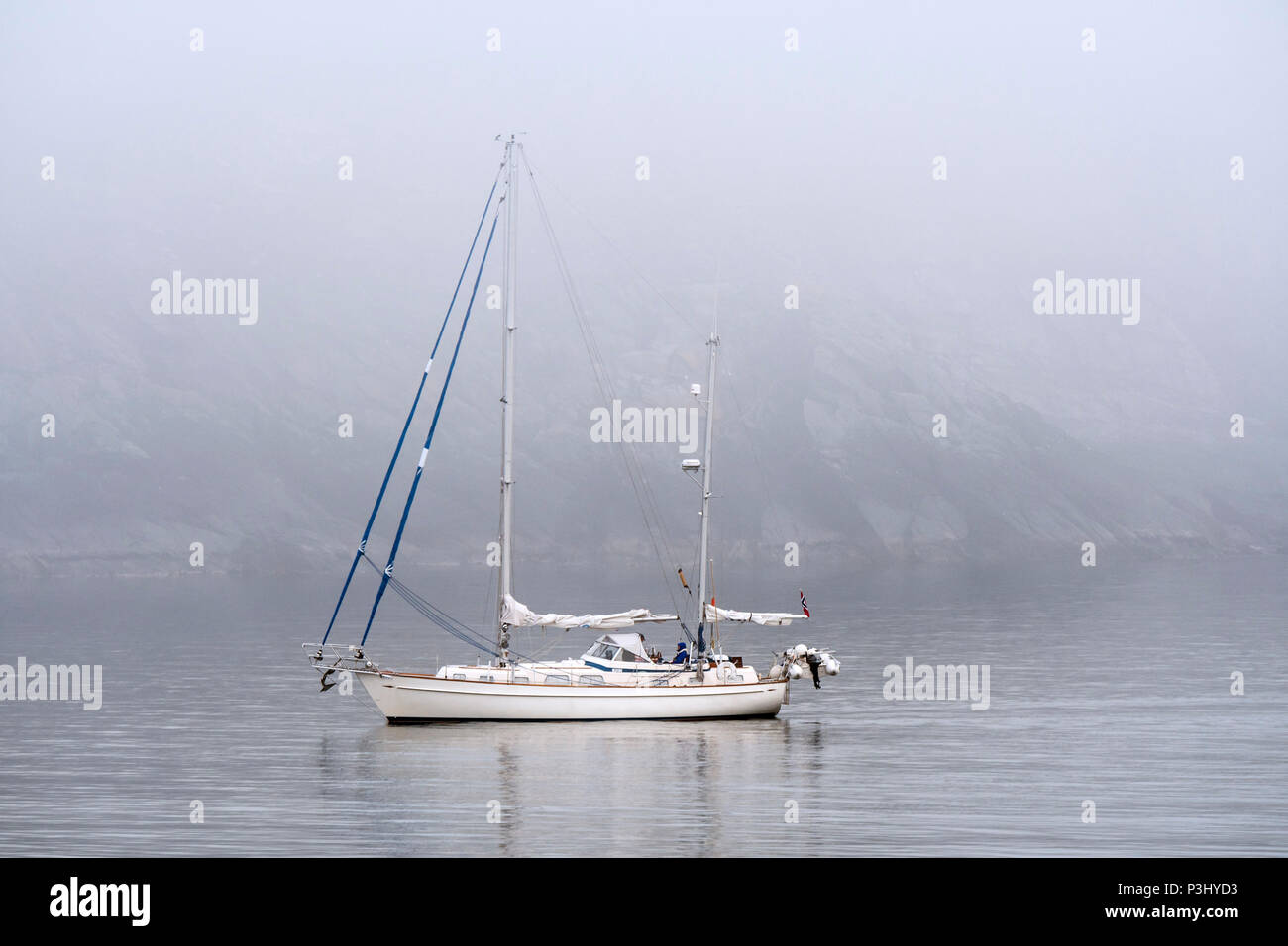 Sailboat / sailing boat / yacht with lowered sails at sea during bad ...