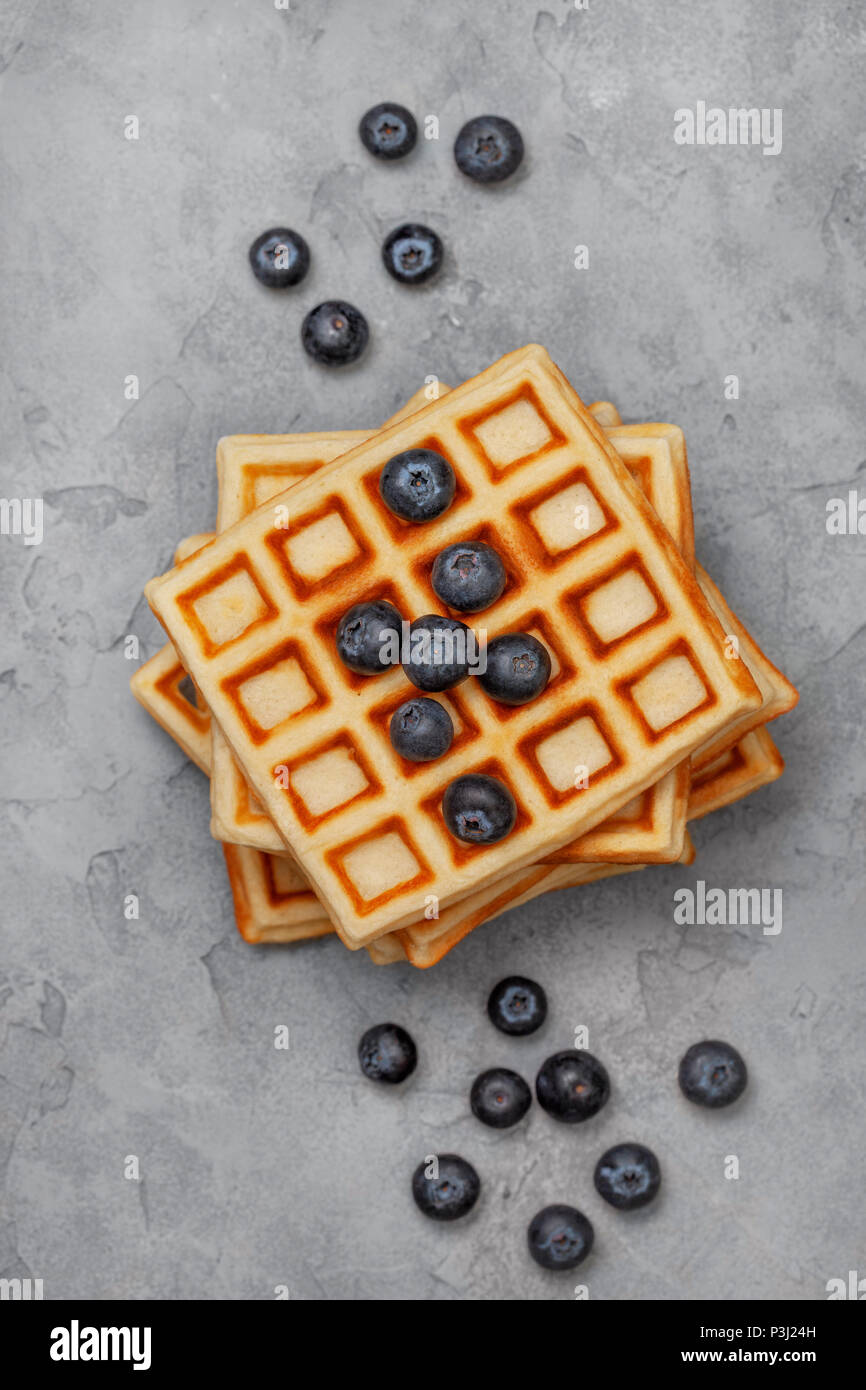stack of belgian waffles with blueberries on a grey background. view ...