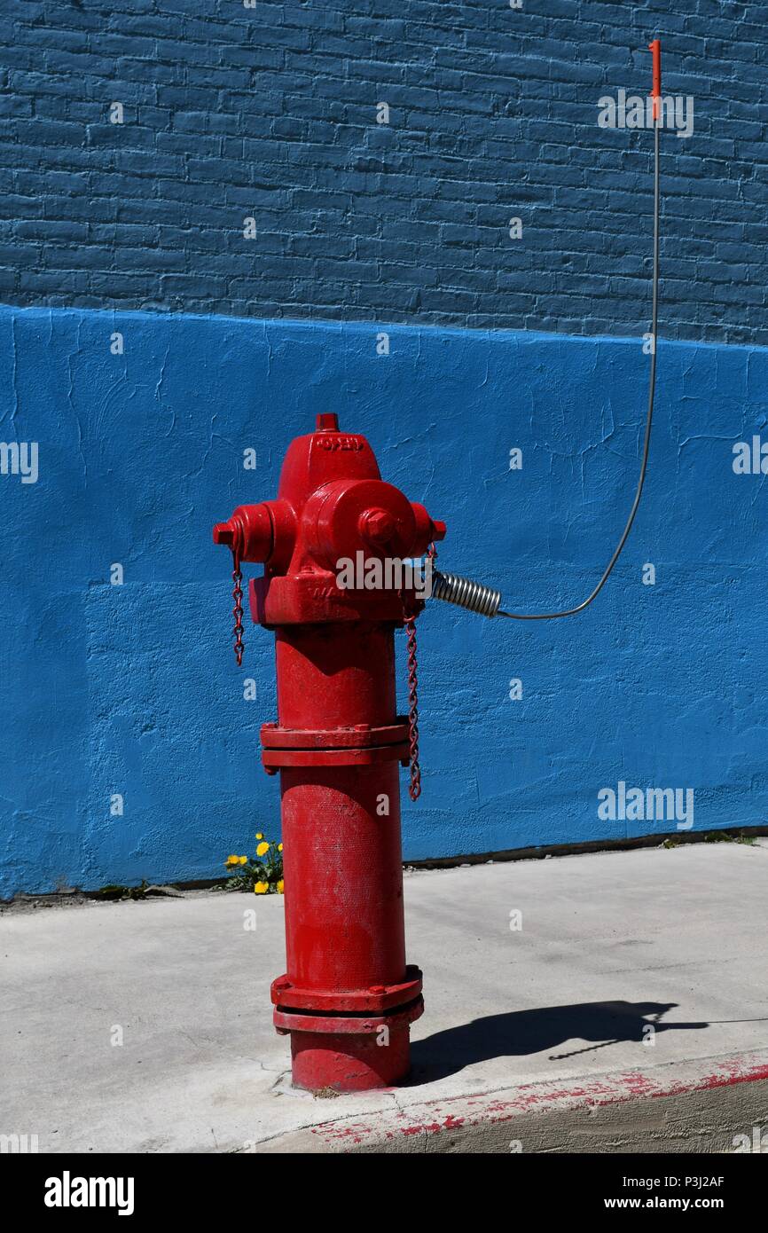 Bright red fire hydrant against blue wall in Silverton Stock Photo - Alamy