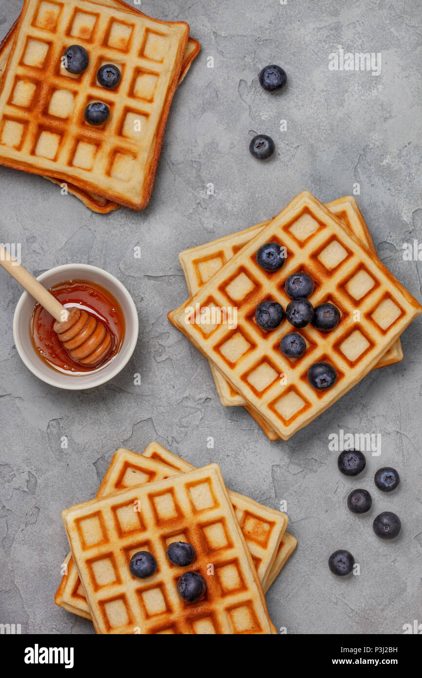 stack of belgian waffles with blueberries on a grey background. view ...