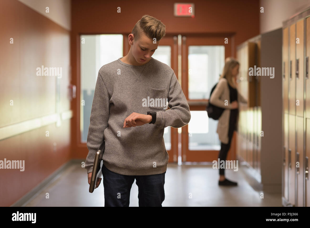 Teenage boy checking time on smartwatch Stock Photo - Alamy