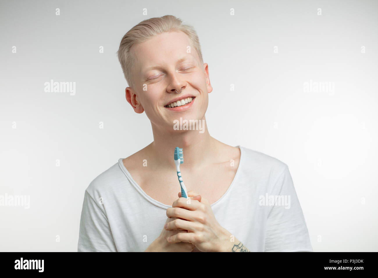 Man with closed eyes holding toothbrush in hand. Dental care and teeth ...