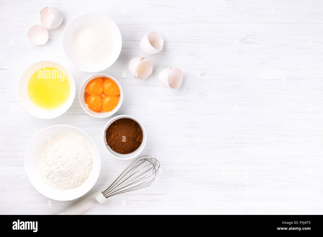 Ingredients for baking sponge cake. Eggs, flour, sugar, cacao and whisk ...