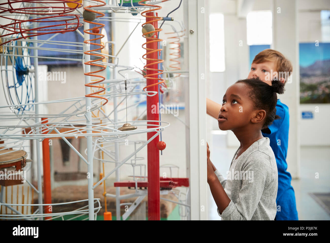Two kids looking at a science exhibit, waist up Stock Photo - Alamy