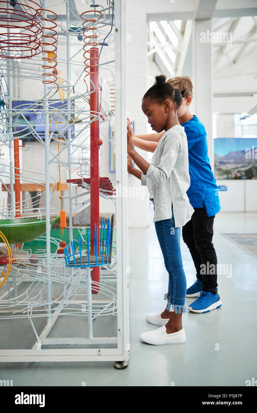 Two kids and looking at a science exhibit, vertical Stock Photo - Alamy