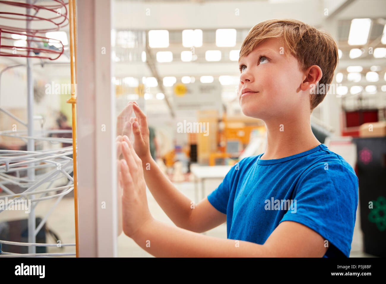 Young white boy looking up at science exhibit, close up Stock Photo - Alamy