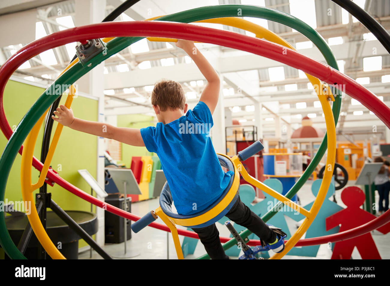Young white boy using human gyroscope, back view Stock Photo - Alamy
