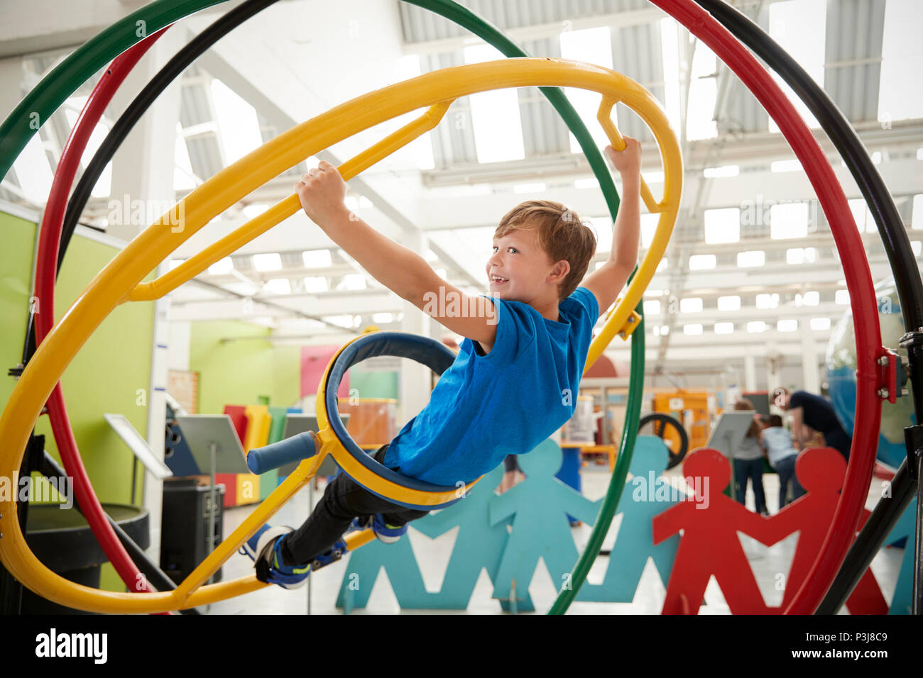 Schoolboy in science centre using human gyroscope, side view Stock ...