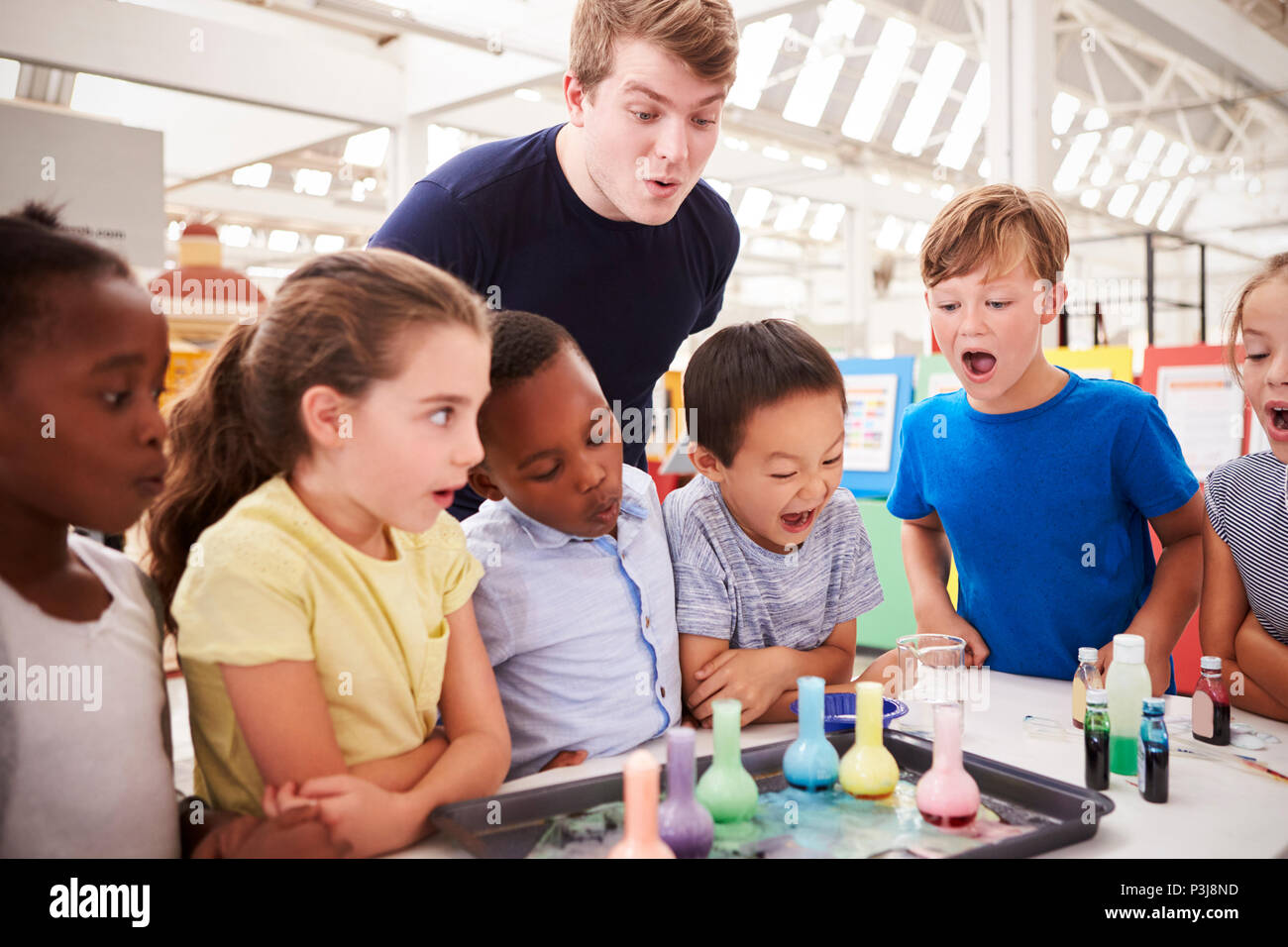 School kids and teacher watch experiment at a science centre Stock ...