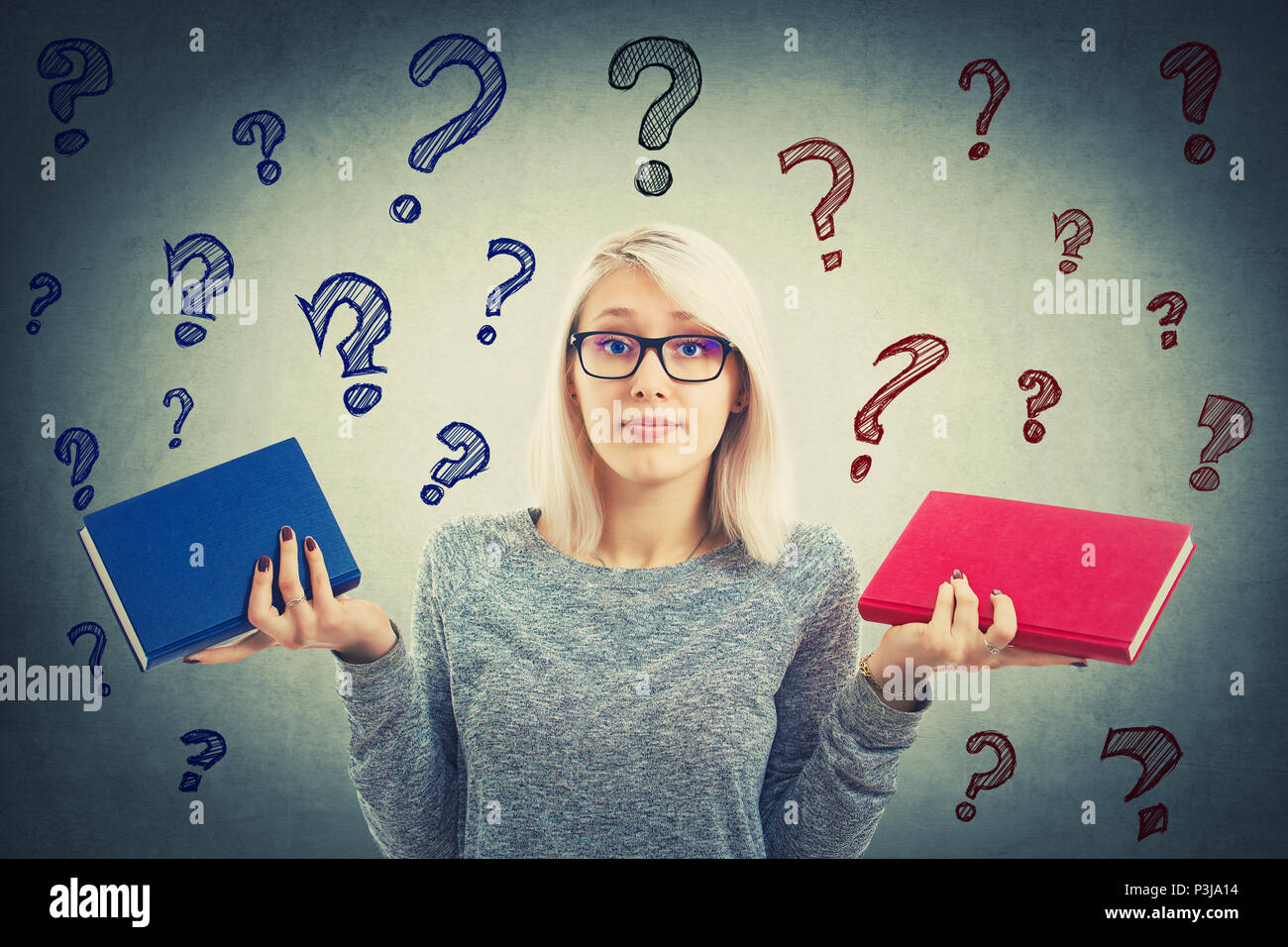 Confused student girl choosing between two books, red and blue, left or ...
