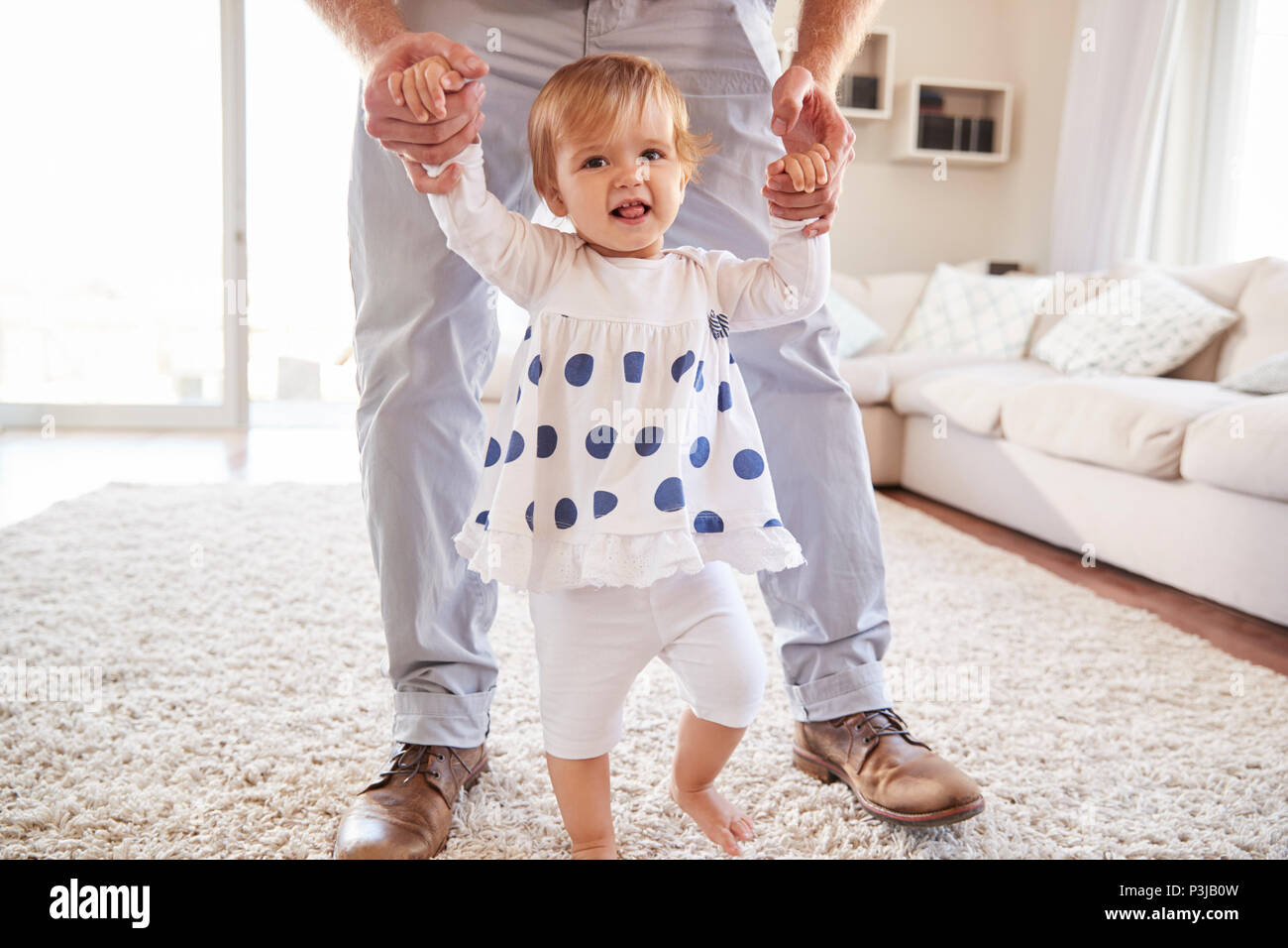 Child helping toddler walk hi-res stock photography and images - Alamy