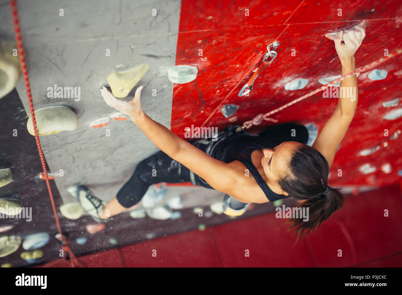 Young girl on an indoor climbing wall hi-res stock photography and ...