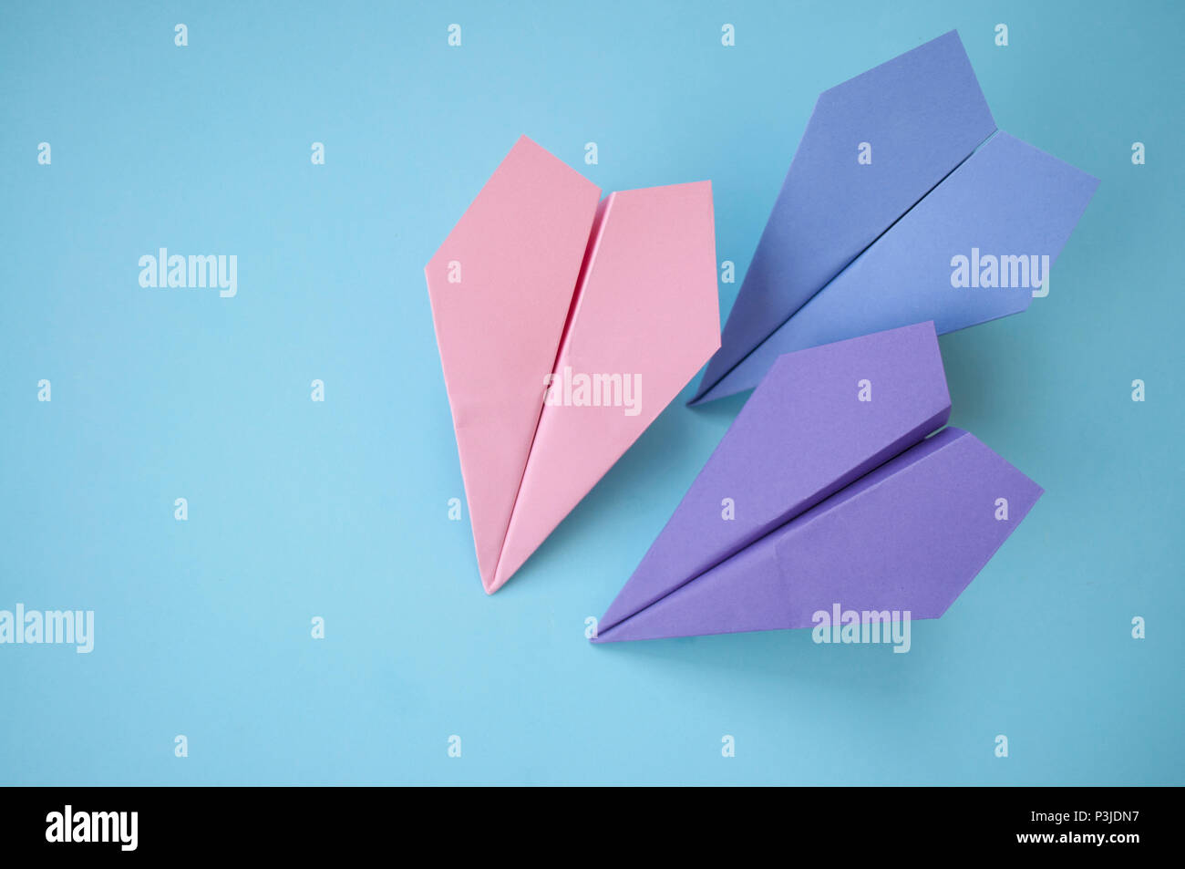 Flat lay of three paper planes on pastel blue background with text ...