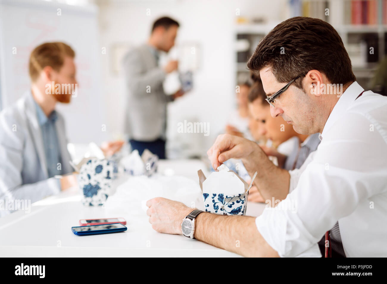 Business people eating in office Stock Photo - Alamy