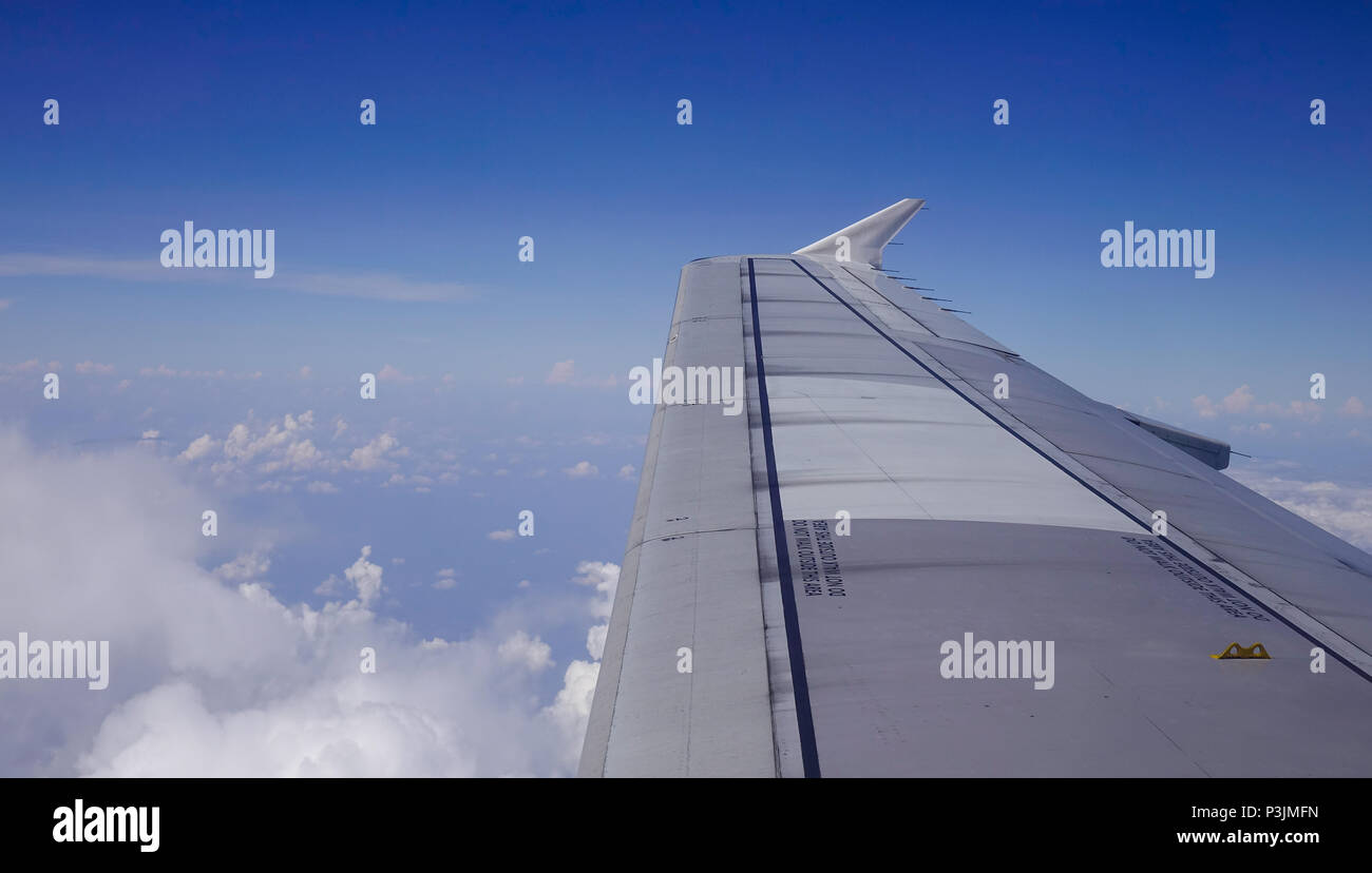 An airplane wing through airplane window with blue sky background Stock ...