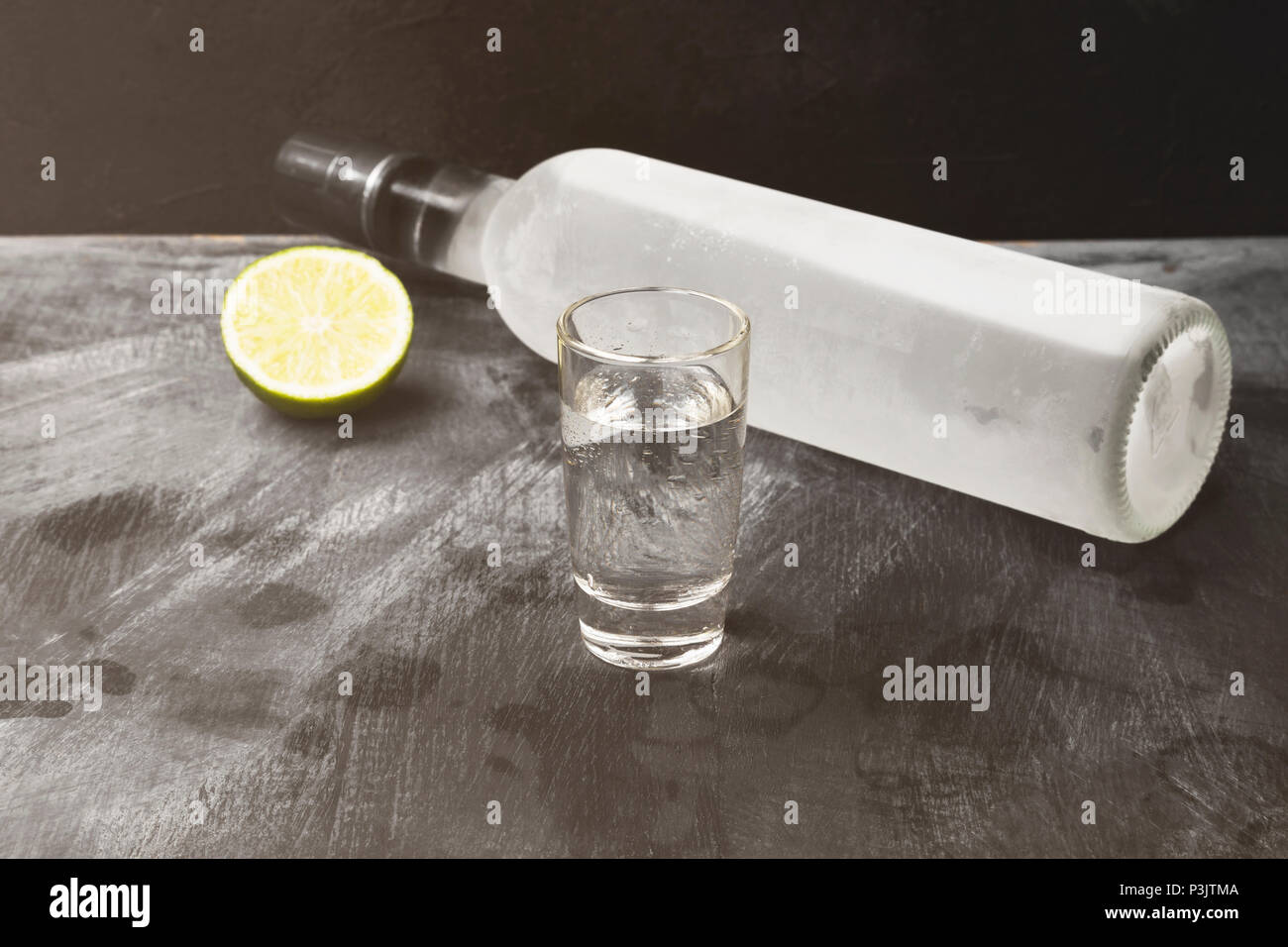 Cold vodka in shot glasses on a black background. Toned Stock Photo - Alamy