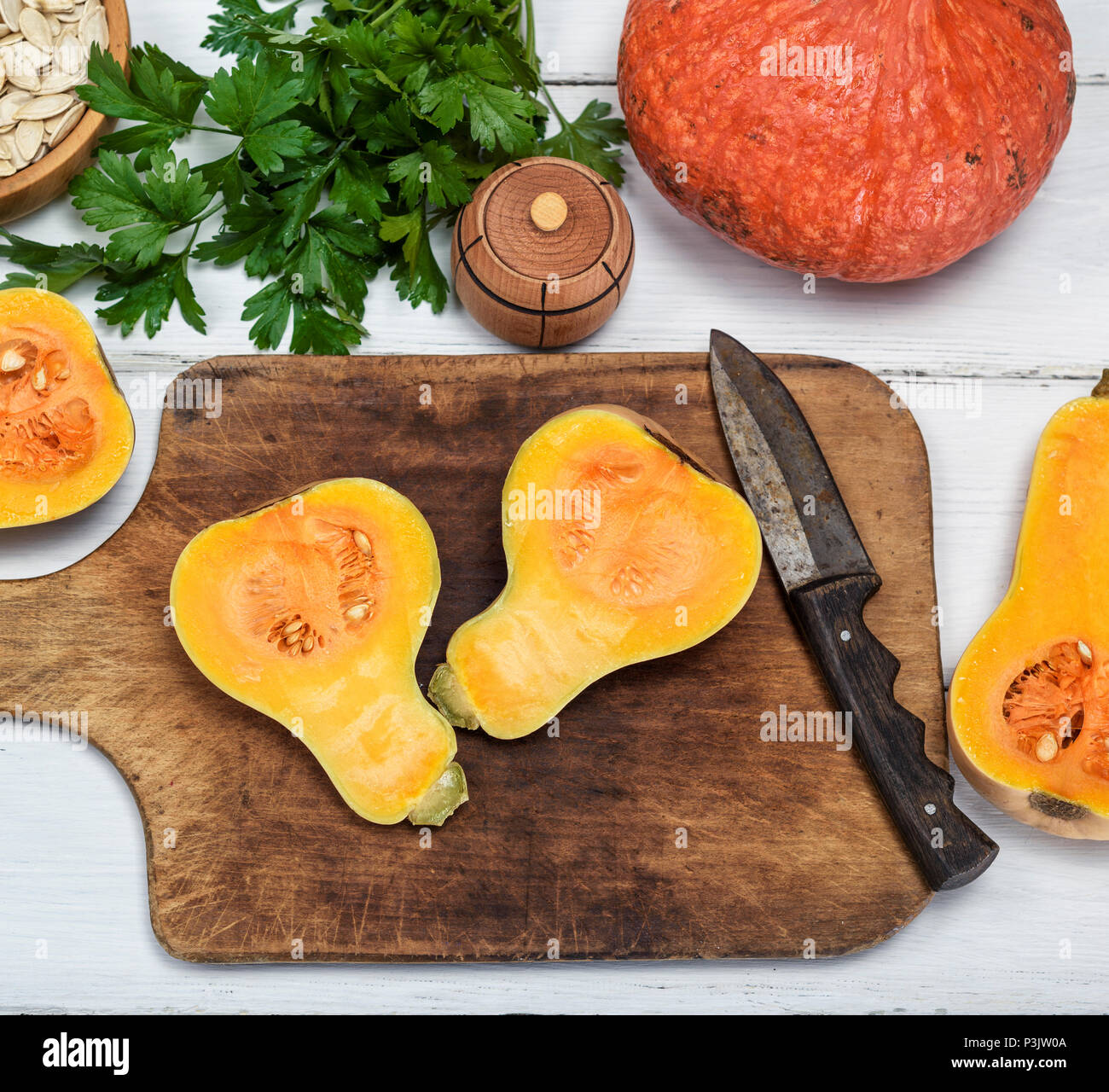 fresh raw pumpkin cut in half on a brown wooden board, top view Stock ...