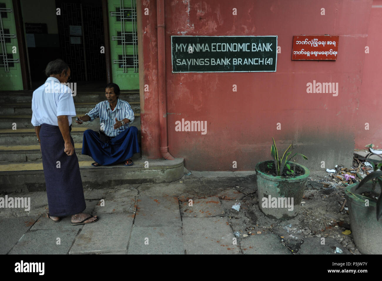 Yangon, Myanmar, men in front of a branch of Myanma Economic Bank Stock ...