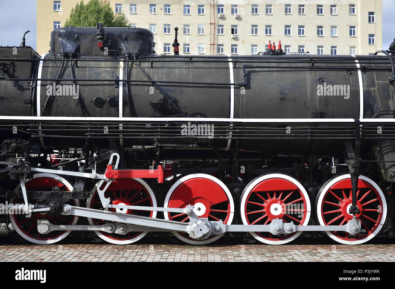Red wheels of old USSR black steam locomotive. Wheels of an old soviet ...