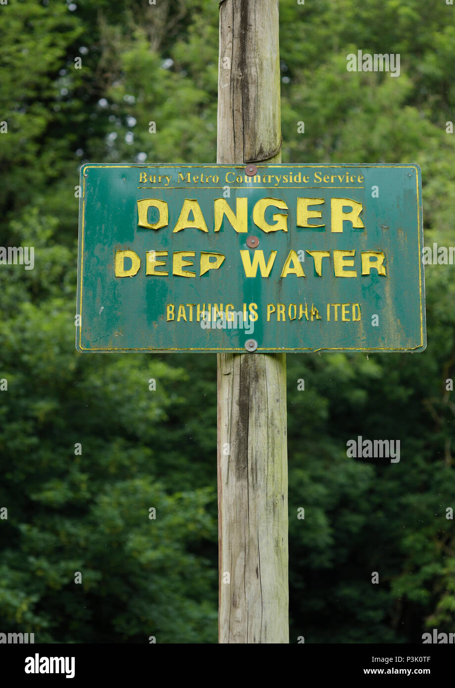 Danger deep water sign with green background, yellow lettering peeling ...