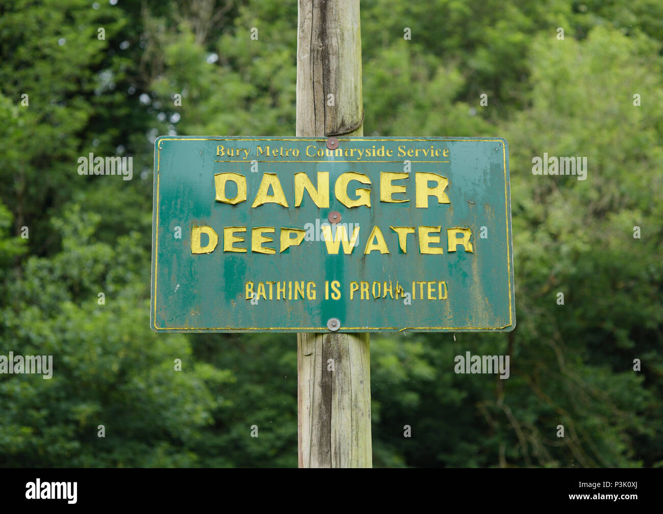 Danger deep water sign with green background, yellow lettering peeling ...