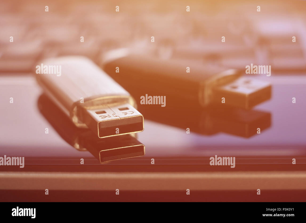 USB flash cards lying on black laptop case in front of his keyboard ...