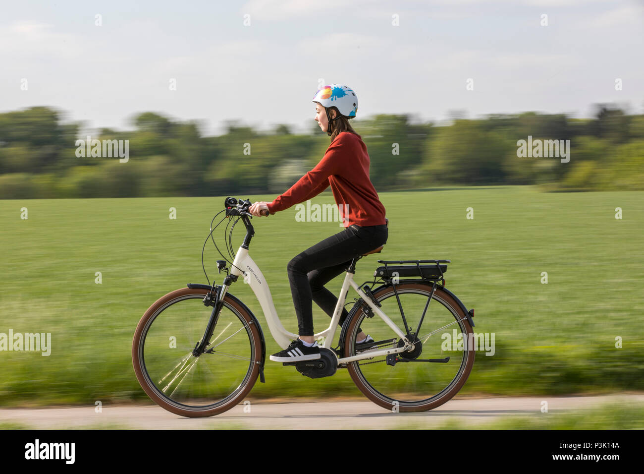 Young woman rides an e-bike, electric bike, electric motor assisted ...