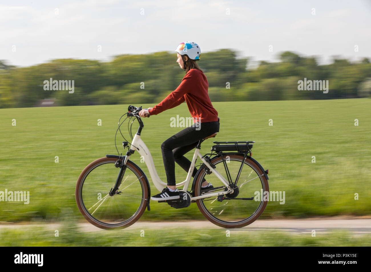 Young woman rides an e-bike, electric bike, electric motor assisted ...