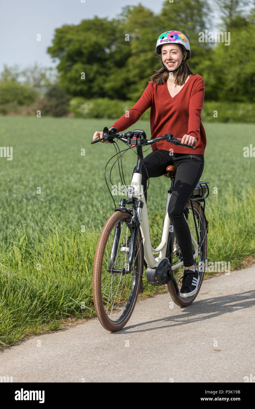 Young woman rides an e-bike, electric bike, electric motor assisted ...