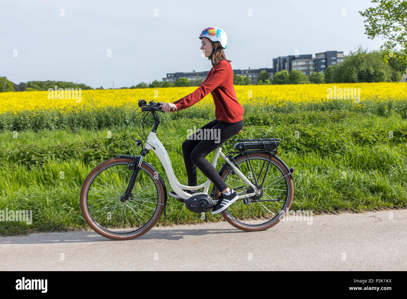 Young woman rides an e-bike, electric bike, electric motor assisted ...