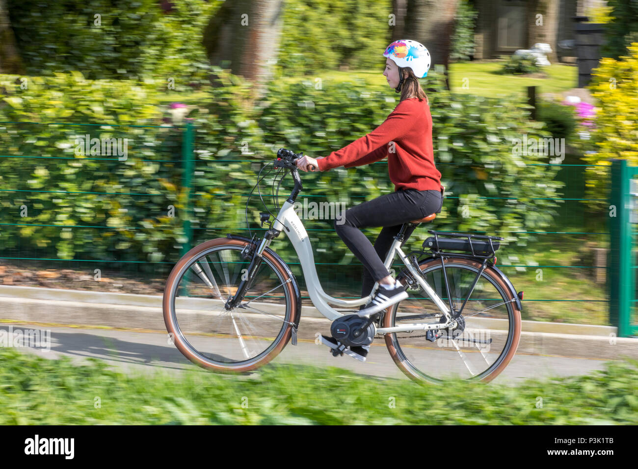 Young woman rides an e-bike, electric bike, electric motor assisted ...