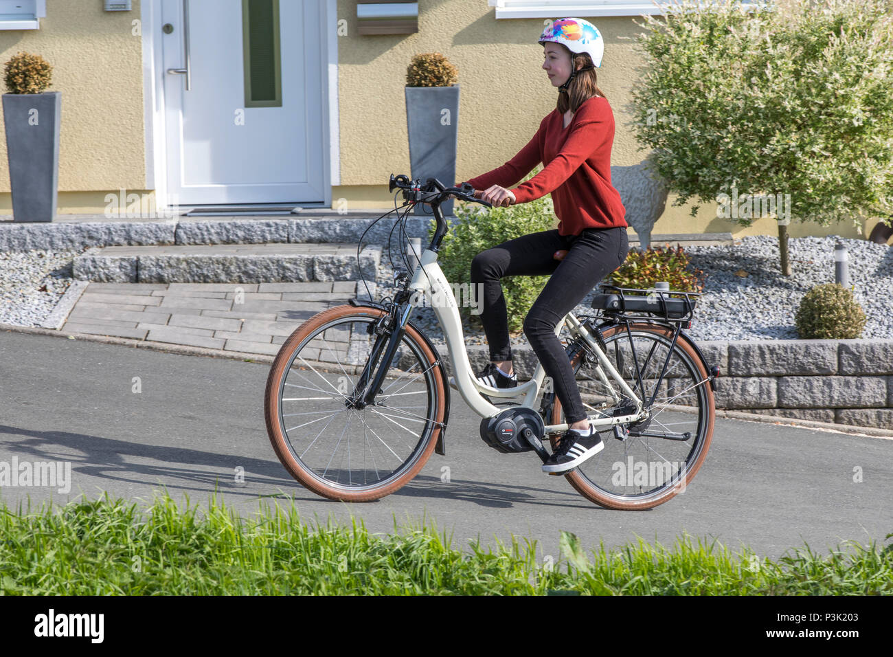 Young woman rides an e-bike, electric bike, electric motor assisted ...