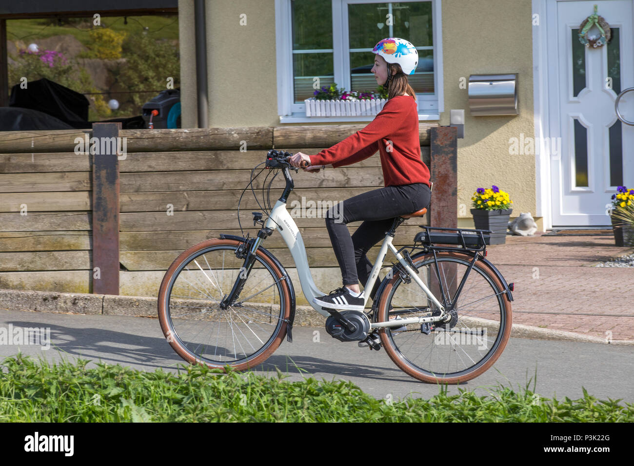 Young woman rides an e-bike, electric bike, electric motor assisted ...