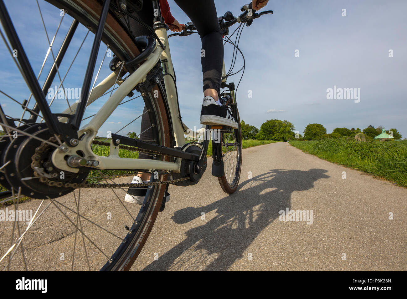 Young woman rides an e-bike, electric bike, electric motor assisted ...
